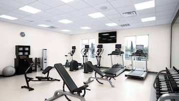 Uma academia com diversos equipamentos de exercício, incluindo esteiras, bicicletas ergométricas e aparelhos de musculação.
