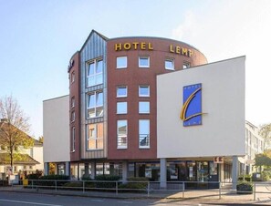 Um hotel chamado HOTEL LEMP, com design moderno, apresentando diversas janelas e um logotipo marcante na fachada.