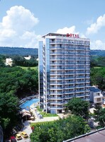 Um hotel moderno com várias varandas e área de piscina.
