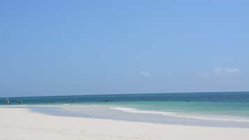 Na praia, praia de areia branca, espreguiçadeiras, toalhas de praia
