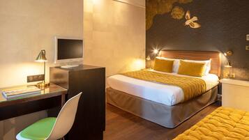 Quarto de hotel com cama, escrivaninha, cadeira e um grande mural na parede.