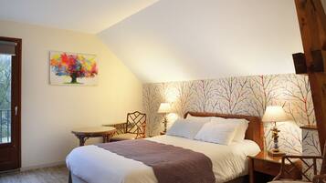 Quarto com uma cama grande, duas mesas de cabeceira com luminárias, uma cadeira e uma janela.