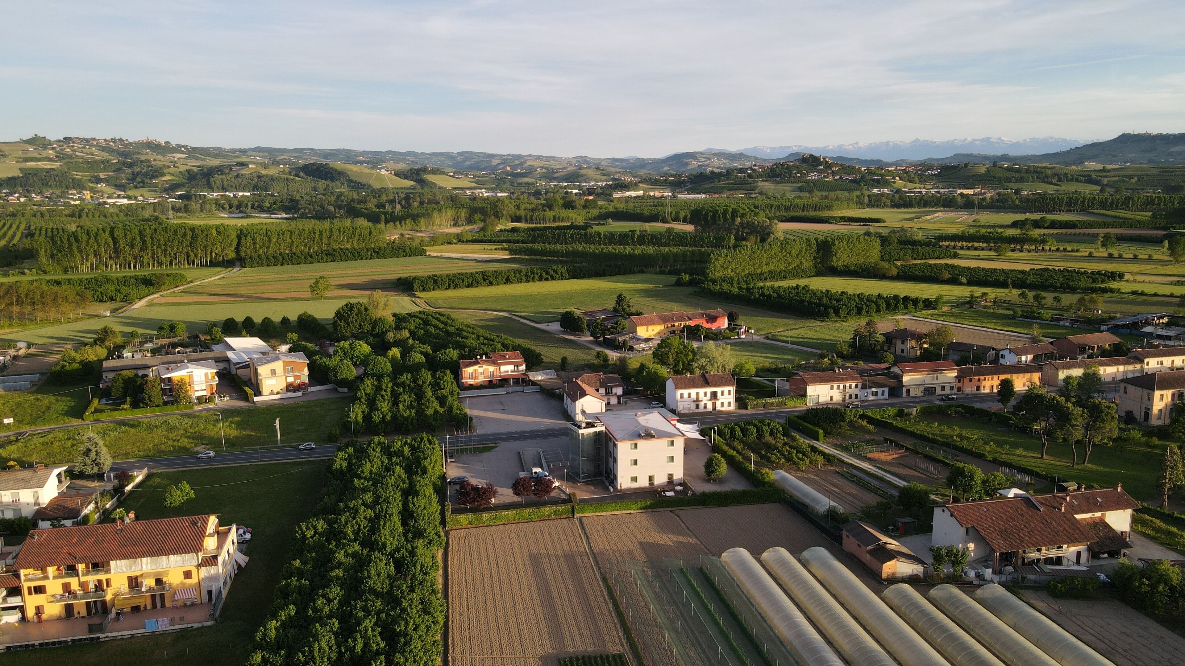 Vista aérea de uma vila rural com casas, campos e estrada.