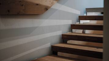 Uma escada de madeira com design moderno, que leva a um andar superior.