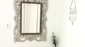 Uma toucador com espelho, castiçais, um comando à distância e um pequeno banco.