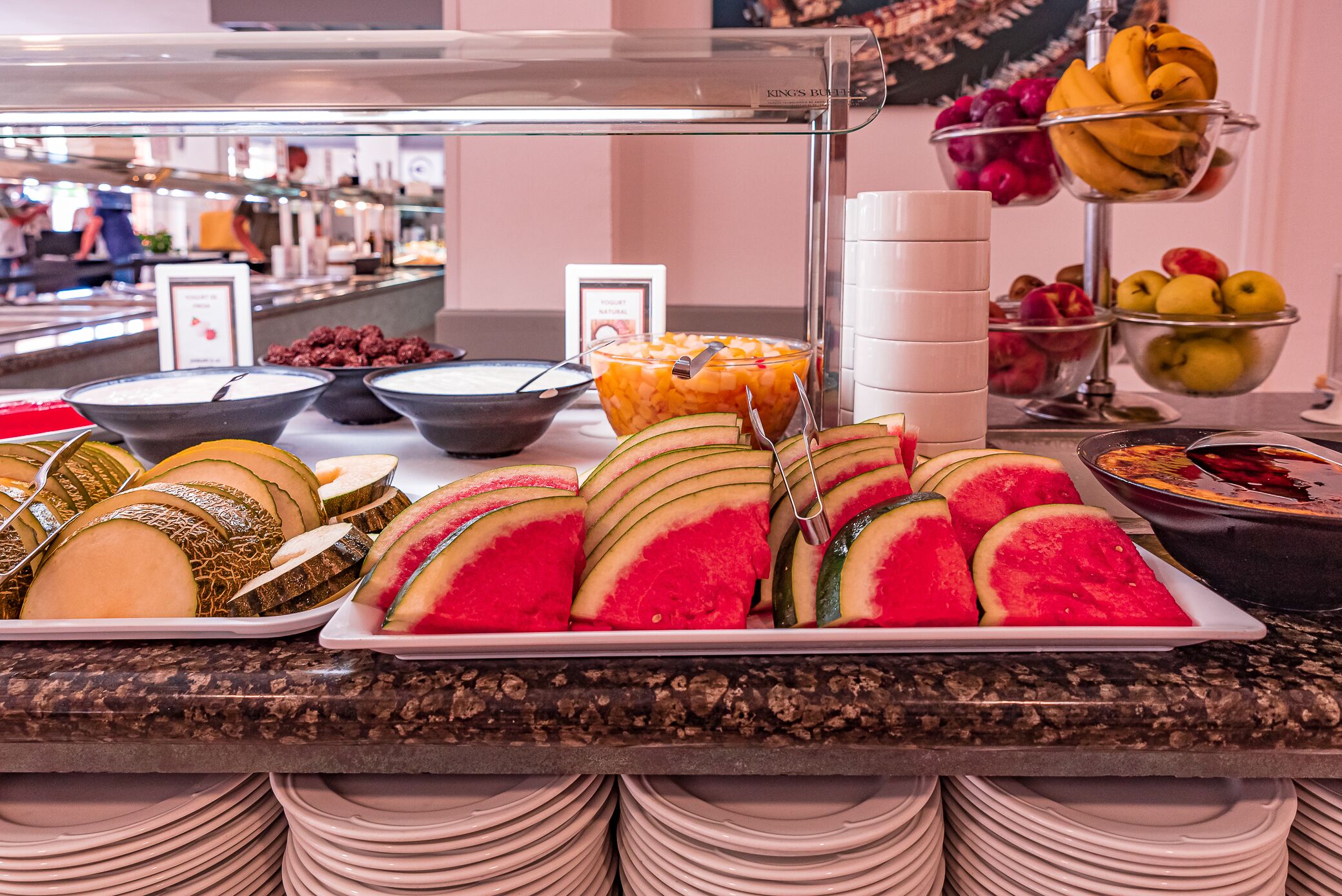 Um buffet com diversas frutas e sobremesas.