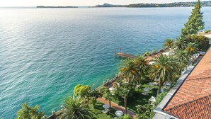 Um hotel à beira-mar com vista para o oceano, um calçadão e palmeiras.
