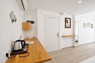 Cozinha moderna com bancada de madeira, chaleira e máquina de café.