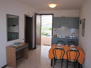Uma cozinha compacta com área de refeições, um banco de madeira e uma mesa posta para quatro pessoas.
