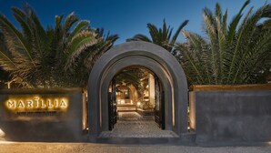 Entrada de hotel com uma placa indicando 'MARILLIA' e um caminho em arco que leva ao interior.