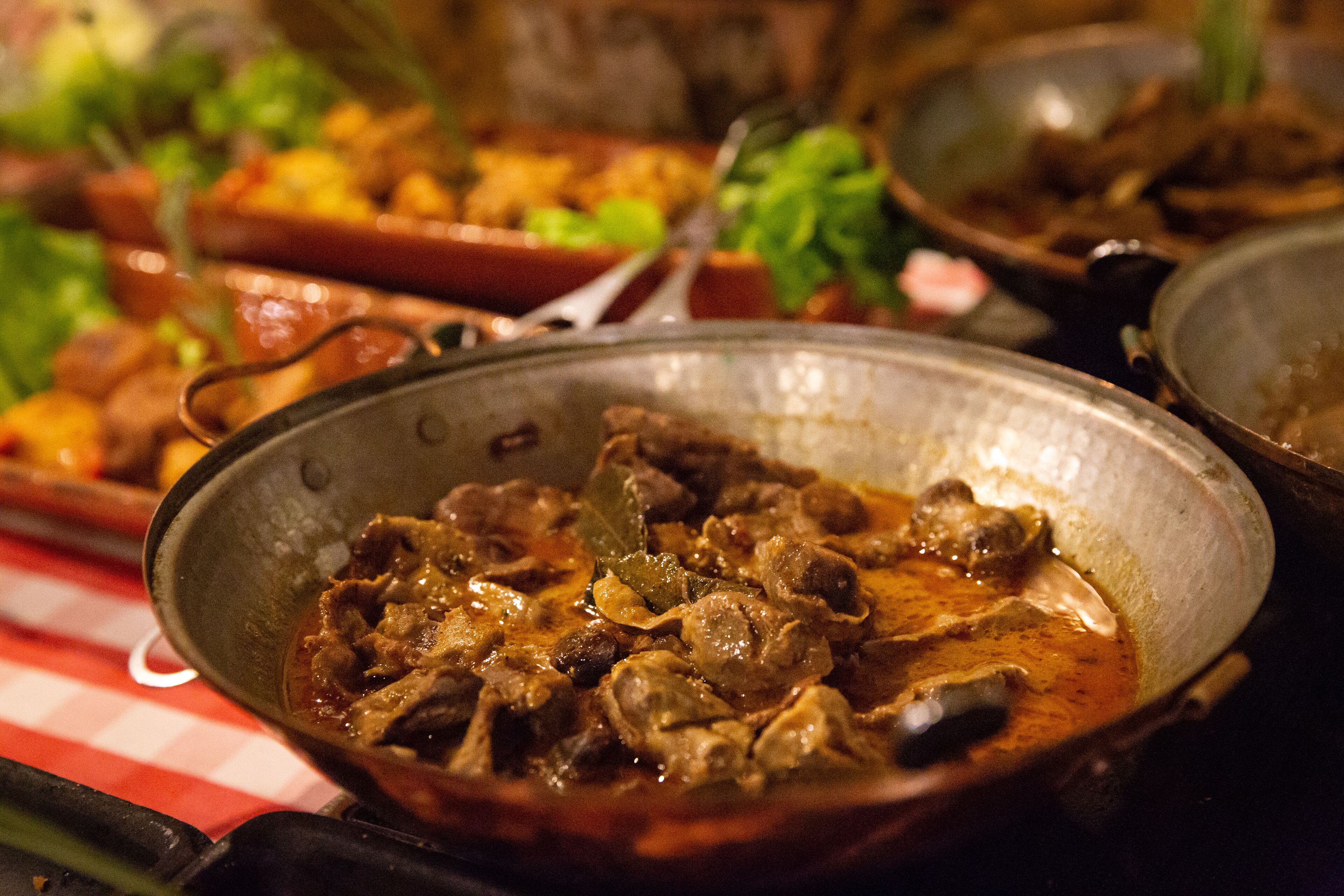 Close-up de um prato com carne e molho, possivelmente em um restaurante.