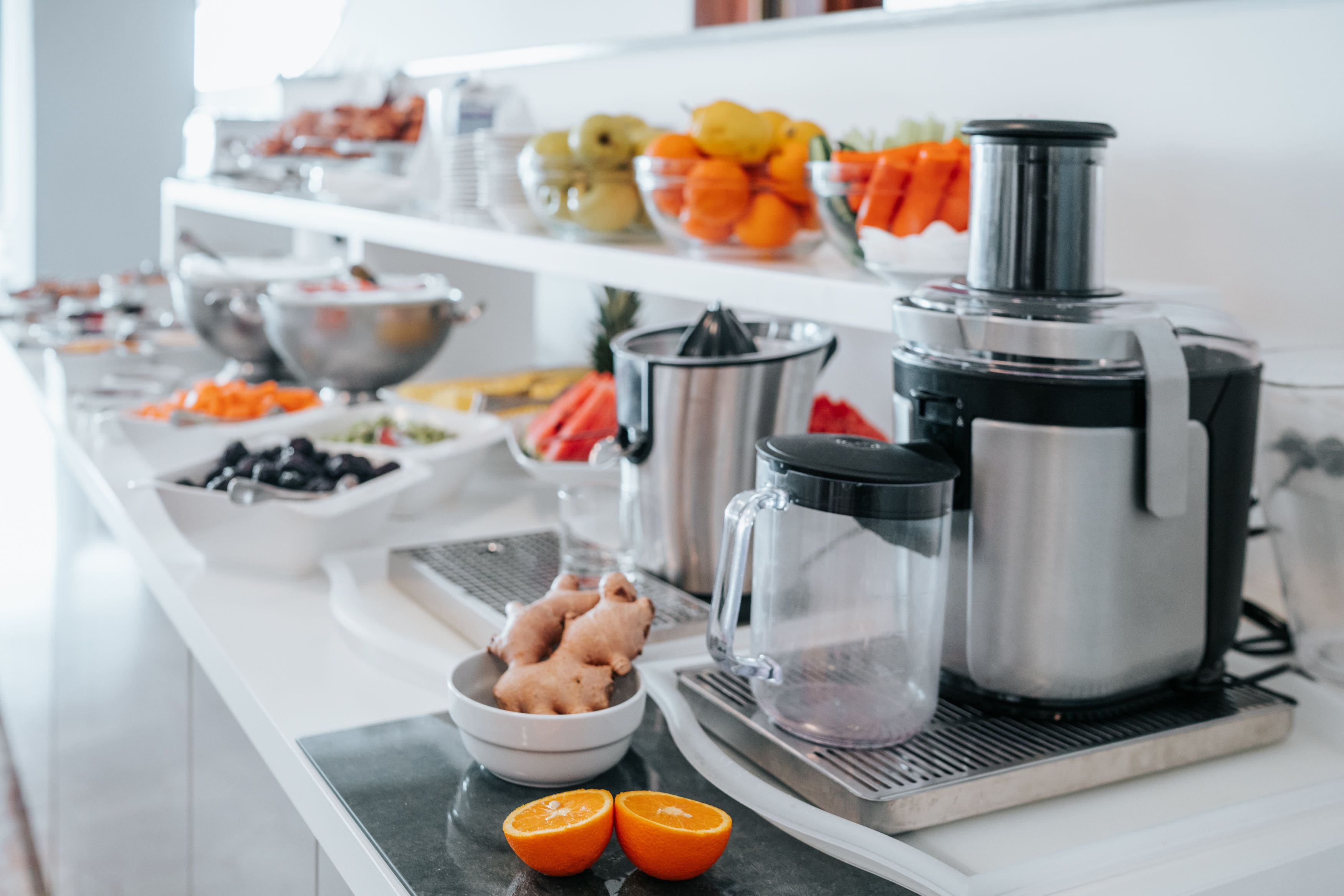 Uma bancada de cozinha com diversos alimentos e eletrodom ésticos.
