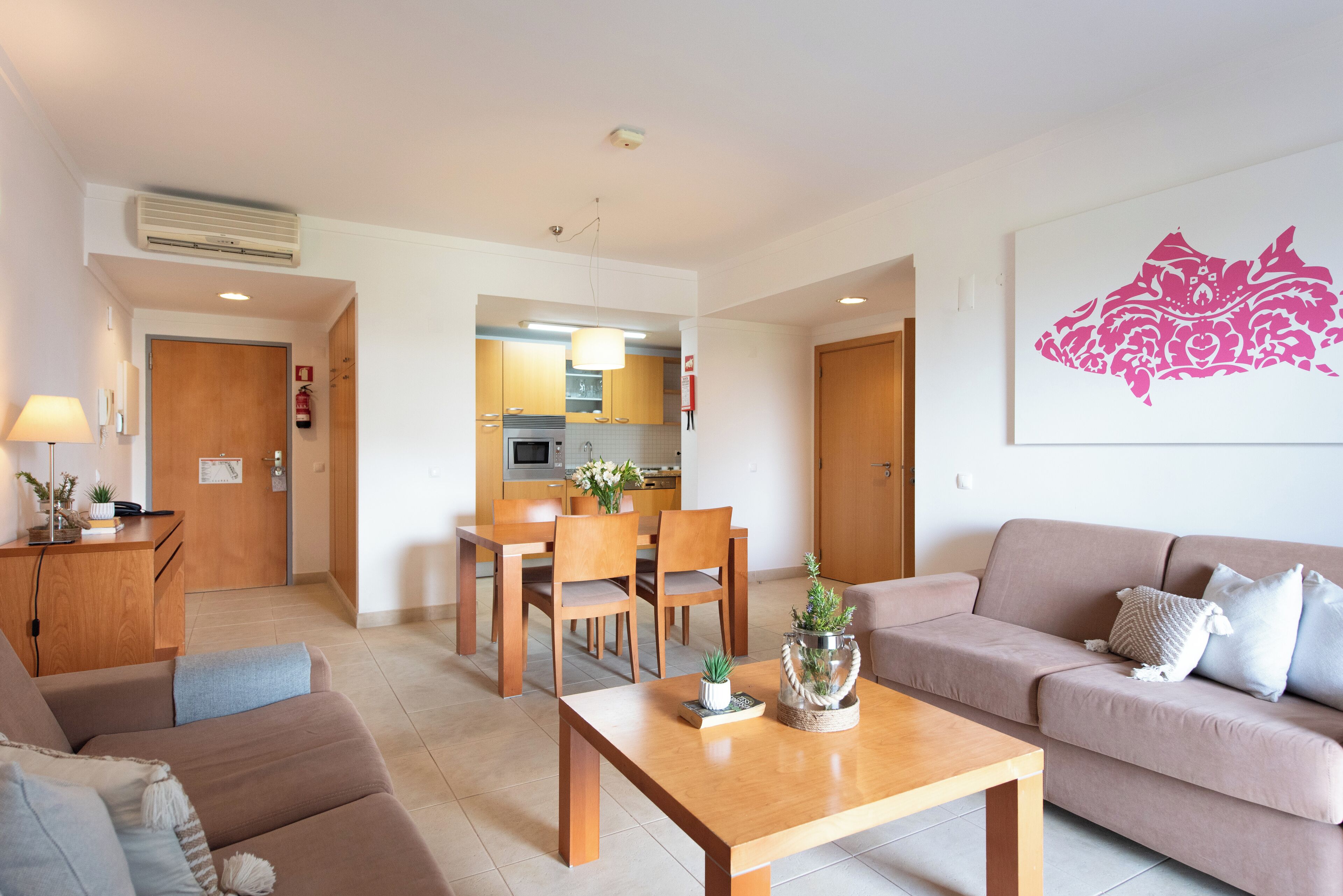 Uma sala de estar moderna com sofá, mesa de centro e área de jantar com cadeiras e mesa.