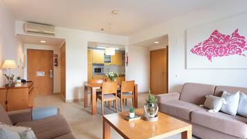 Uma sala de estar moderna com sofá, mesa de centro e área de jantar com cadeiras e mesa.