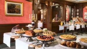 Buffet com diversos doces e pastelaria, um quadro na parede e painéis de madeira.
