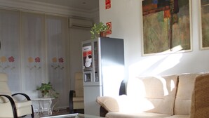 Sala de estar com sofá, mesa de centro e geladeira.