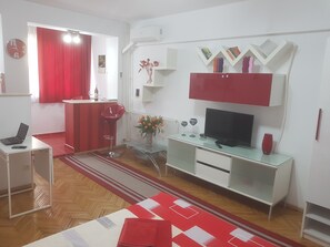 Suíte estúdio luxo | Sala de estar | TV LED, livros