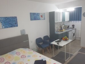 Suíte estúdio luxo | Área de estar | TV LED, livros