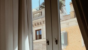Vista pela janela, com moldura branca e porta com puxador.
