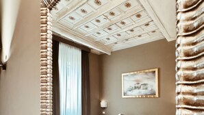 Quarto de hotel com duas camas, uma mesa de jantar e uma cadeira.