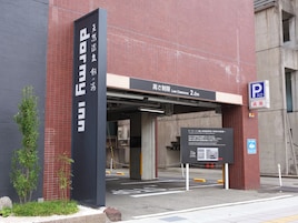 Entrada de estacionamento com aviso de altura limitada e área reservada para veículos elétricos.