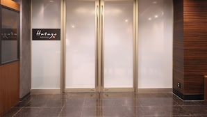 Entrada de um hotel com uma placa indicando 