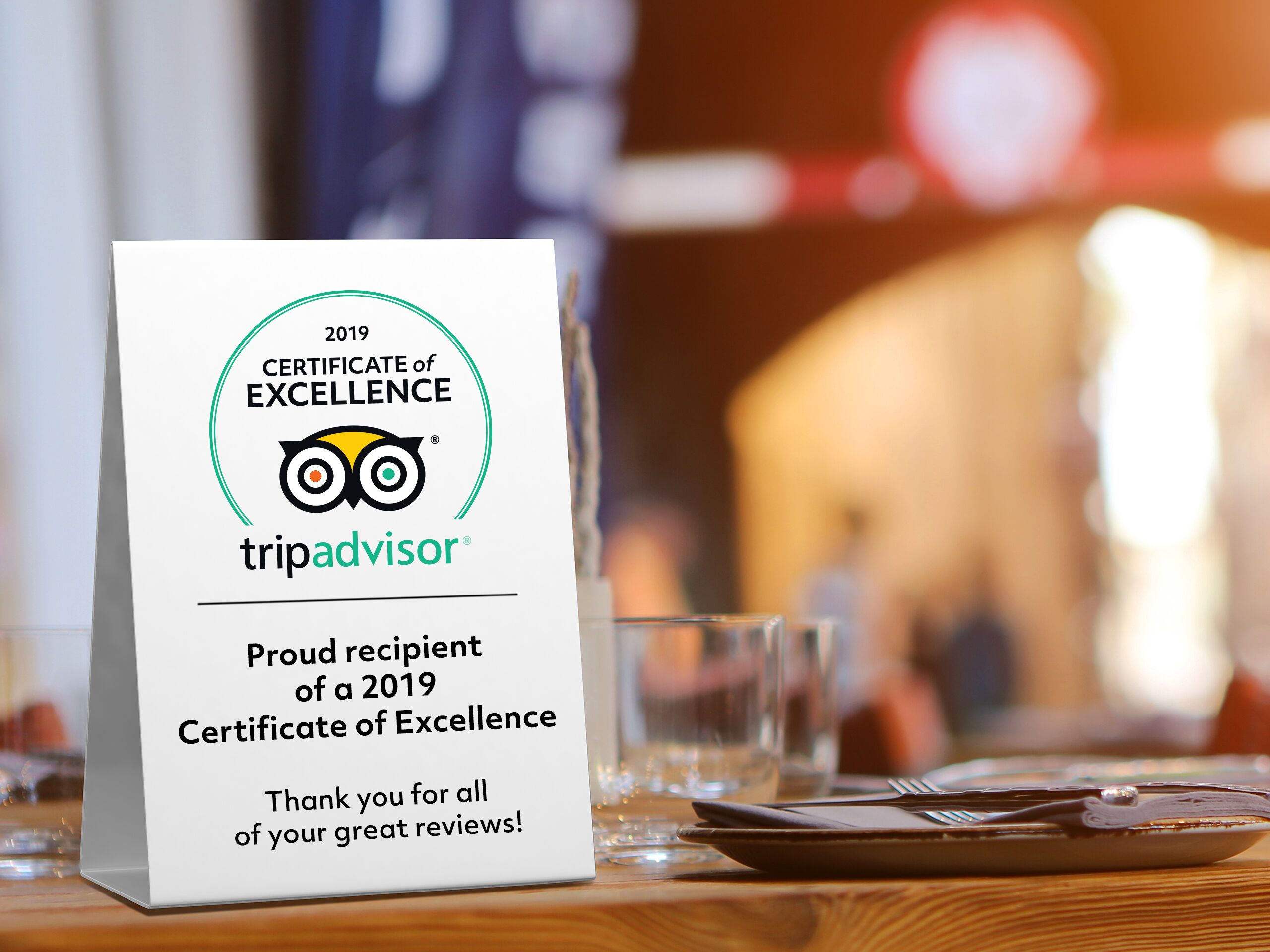 Certificado de excelência sobre uma mesa com um copo e um prato.