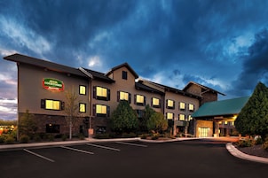 Hotel Courtyard by Marriott com estacionamento, vários edifícios e telhado verde.