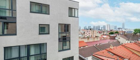 Um edifício moderno com várias janelas e vista para o horizonte urbano ao fundo.