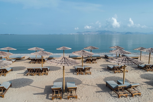 Praia particular, espreguiçadeiras, guarda-sóis, toalhas de praia