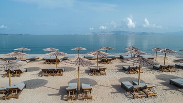 Uma praia privada, espreguiçadeiras, guarda-sóis de praia 