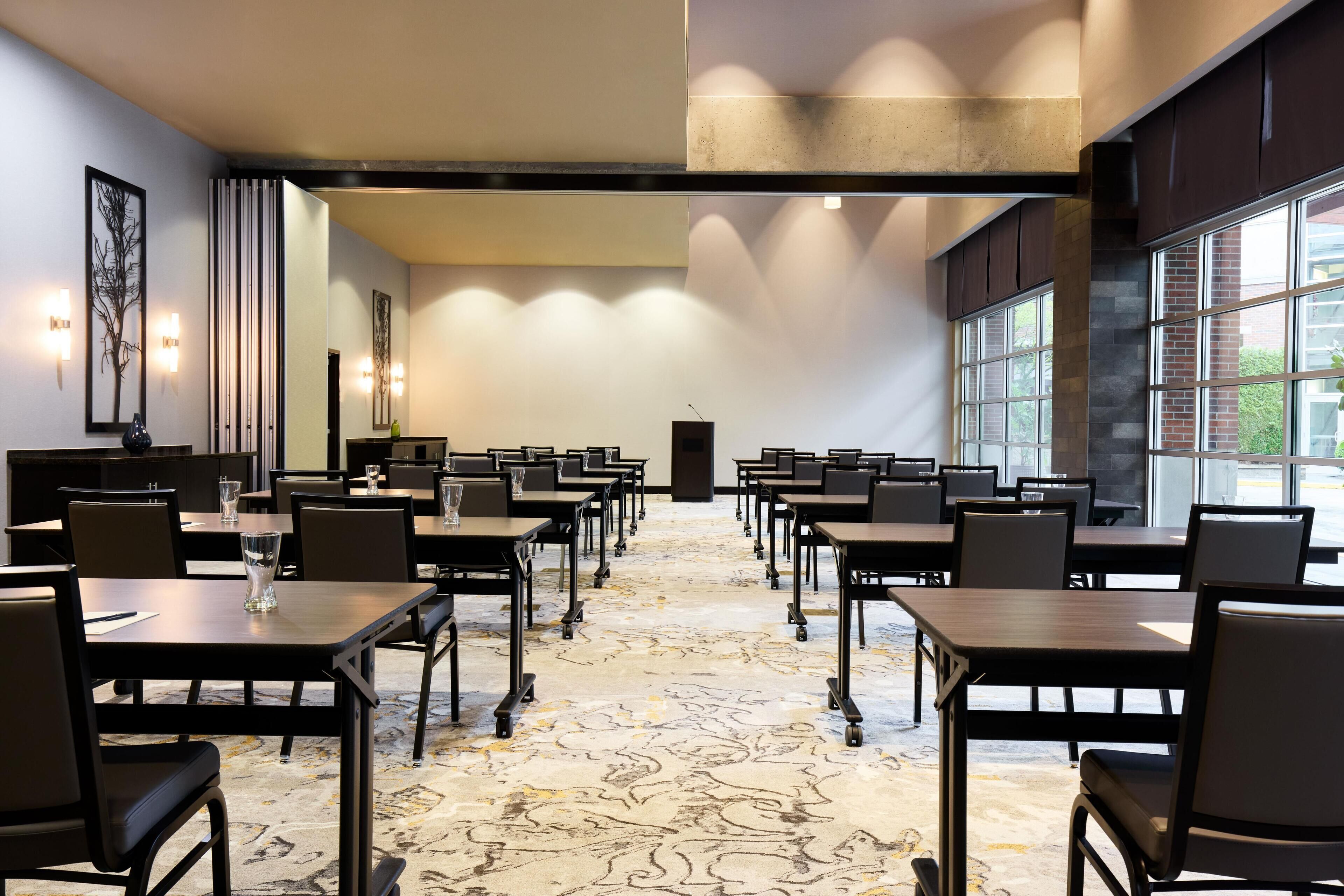 Uma sala de conferências com mesas e cadeiras dispostas para uma reunião.