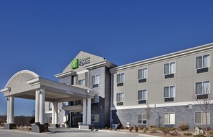 Edifício Holiday Inn Express com entrada coberta, várias janelas e fachada de tijolos.
