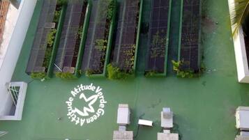 Um jardim no terraço com jardineiras verticais e um logotipo.