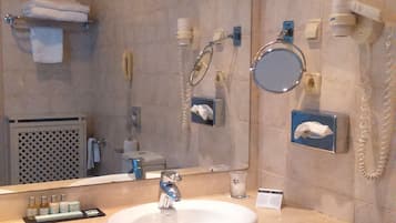 Casa de banho com duas pias, um espelho, telefone e um porta-toalhas.