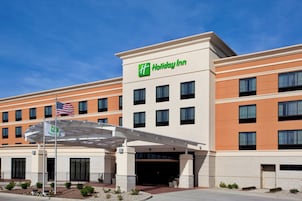 Um hotel Holiday Inn com entrada acessível, área de espera coberta e uma bandeira.