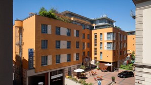Hotel com design moderno, apresentando um pátio central com área de estar ao ar livre e estacionamento.