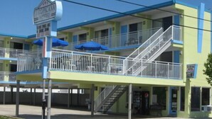 Um motel com estrutura em dois andares, uma galeria coberta e uma escadaria que dá acesso ao andar superior.
