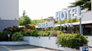Placa de hotel com o nome 'GARDENIA' e sinalização indicando uma área de estacionamento à direita.