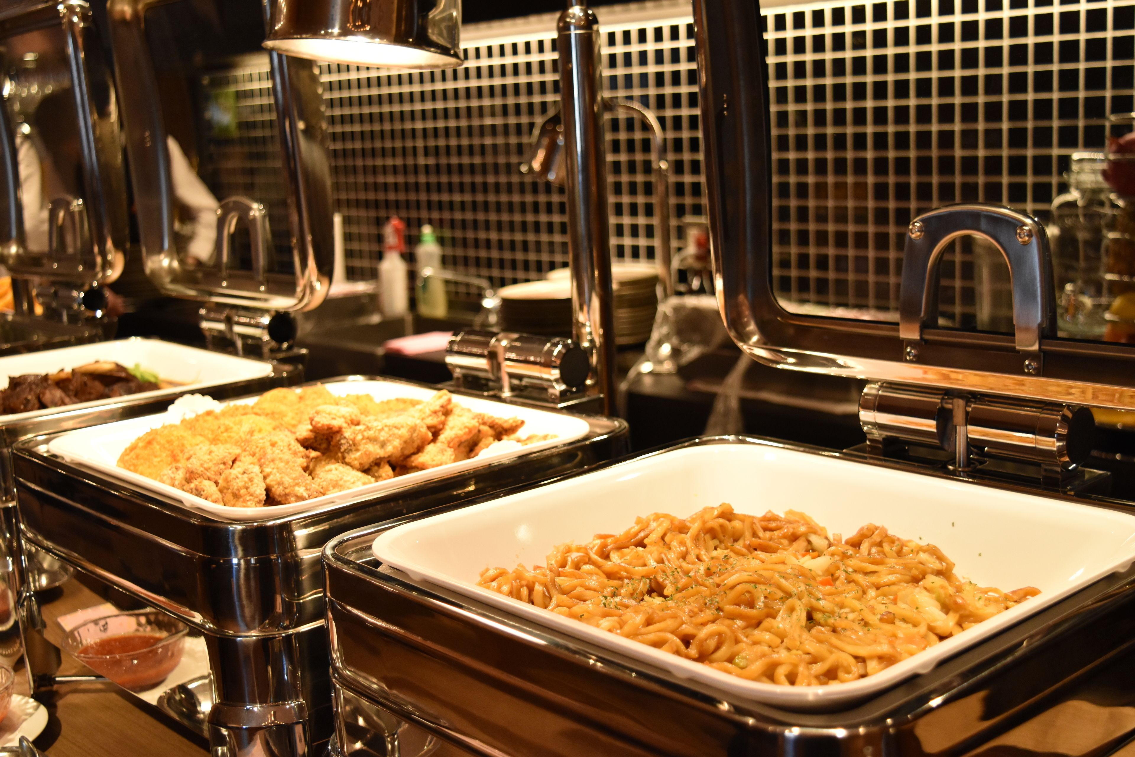 Buffet com massas e frango à milanesa.