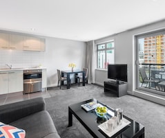 Um apartamento moderno com cozinha, sala de jantar, sala de estar e varanda com vista para a cidade.