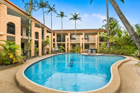 Piscina externa, guarda-sóis, espreguiçadeiras. Oasis Inn Cairns