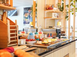 Um buffet de café da manhã com diversos alimentos e uma máquina de café.