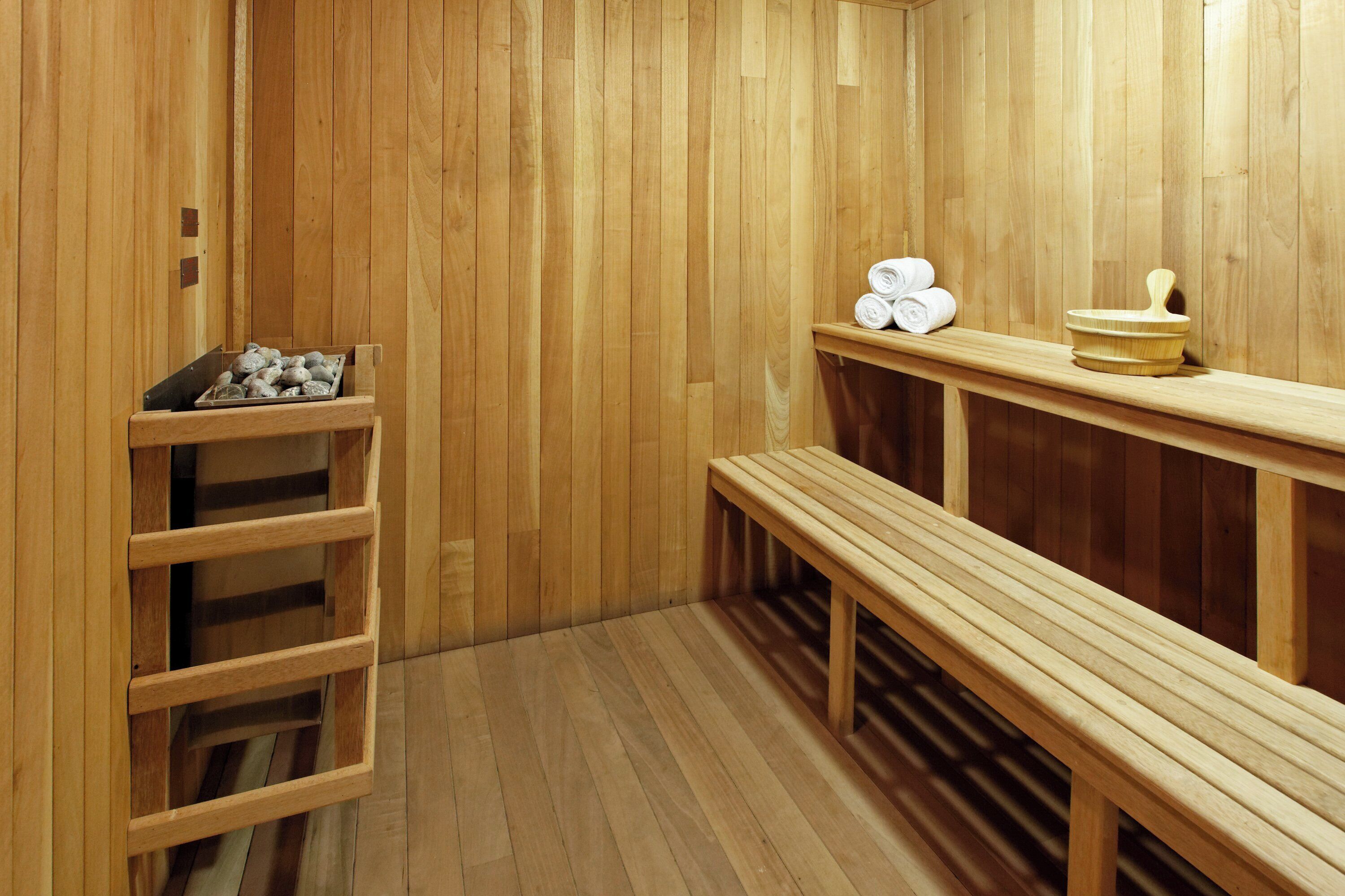 Uma sala de sauna de madeira com bancos e prateleiras.