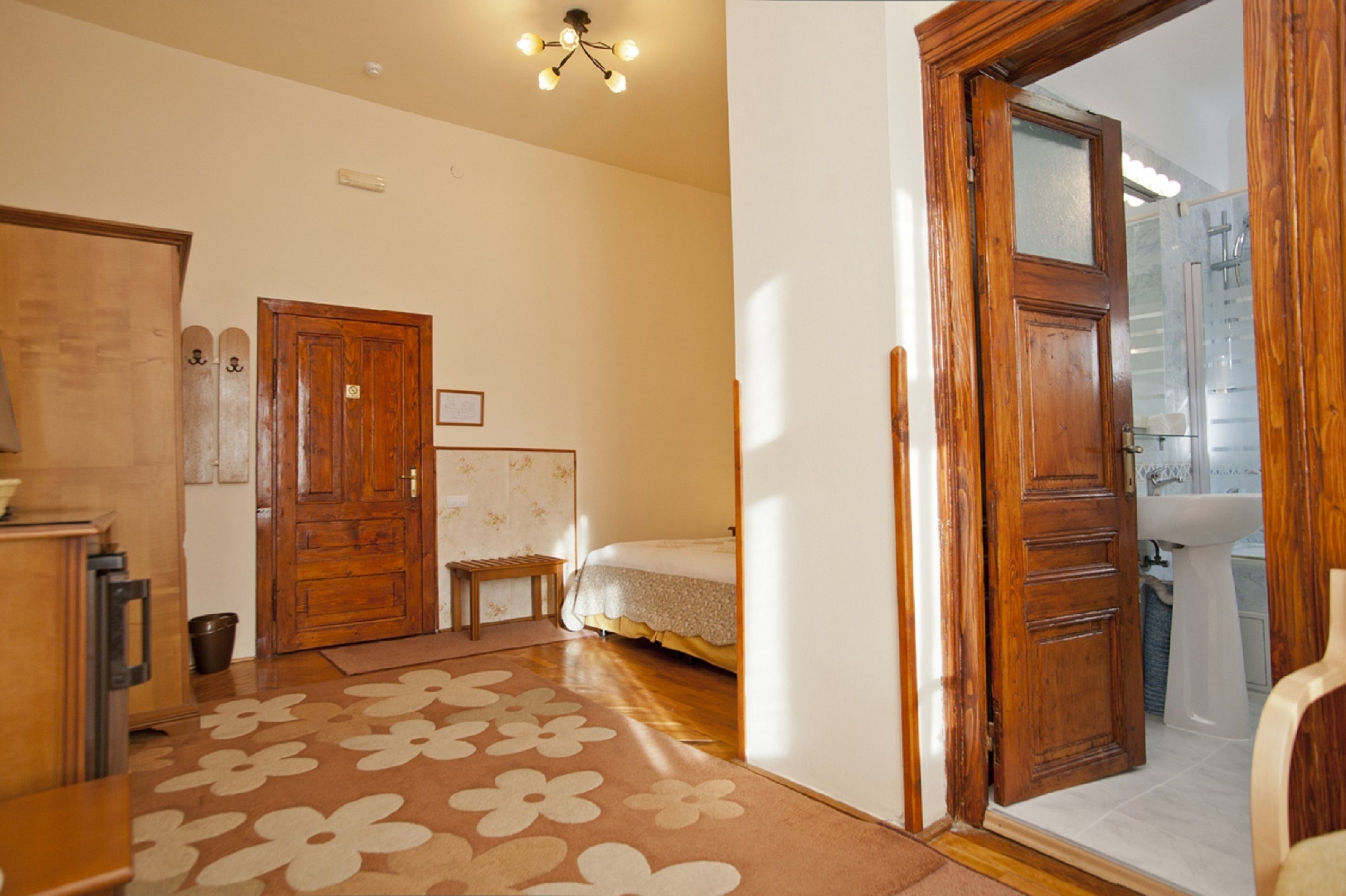 Quarto com cama, porta de madeira e banheiro visível por uma porta aberta.