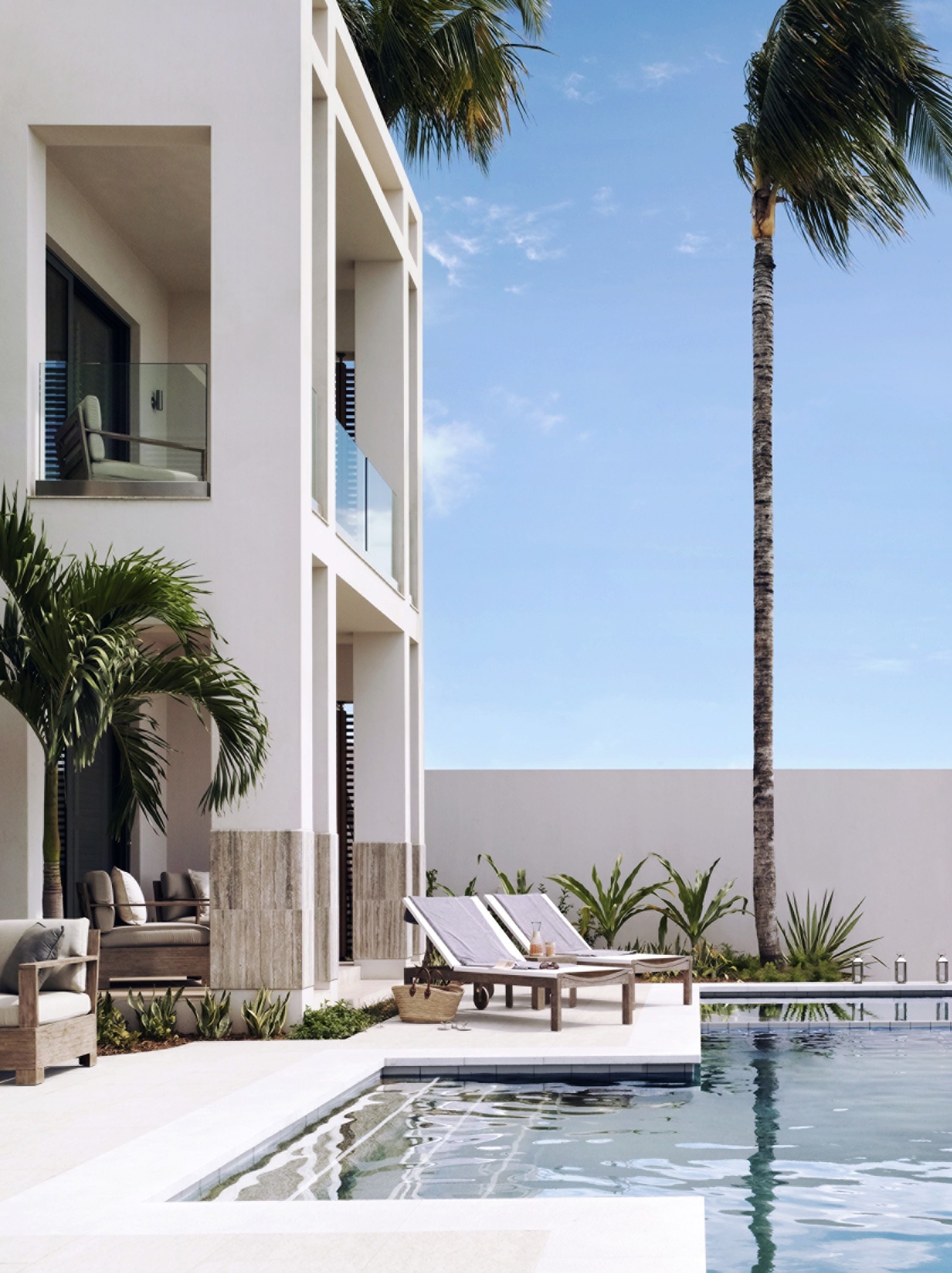Um edifício moderno com piscina, espreguiçadeiras e palmeiras.