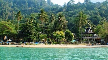 Na praia, guarda-sóis de praia, toalhas de praia