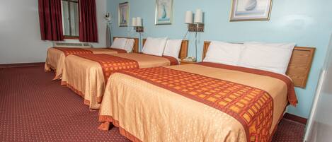 Quarto de hotel com duas camas, carpete vermelho e luminárias fixadas na parede.
