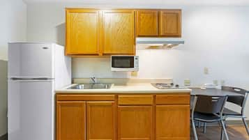 Um frigorífico/congelador grande, um micro-ondas, uma placa de cozinha