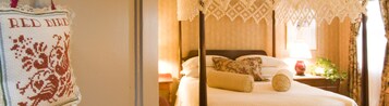 Um quarto aconchegante com cama de dossel, mesa de cabeceira com abajur e um adorno na parede.